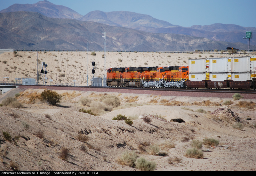 BNSF 7026 and BNSF 7028 head east into the BNSF Barstow yard as they get ready to Pass under the ...